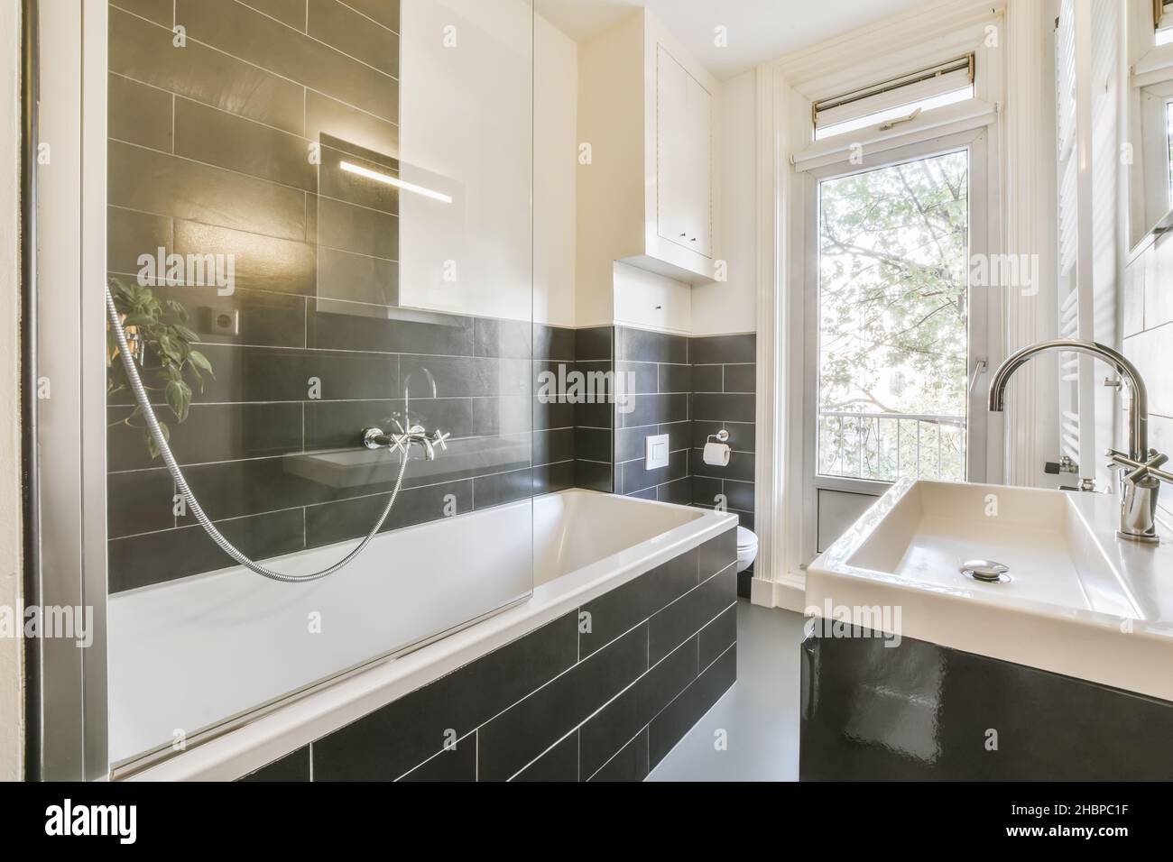 Delightful bathroom in black with a cozy bathtub Stock Photo - Alamy