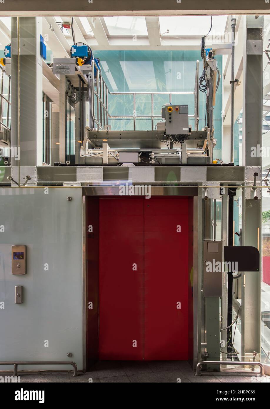 Elevator glass and chrome metal with closed red door in department ...