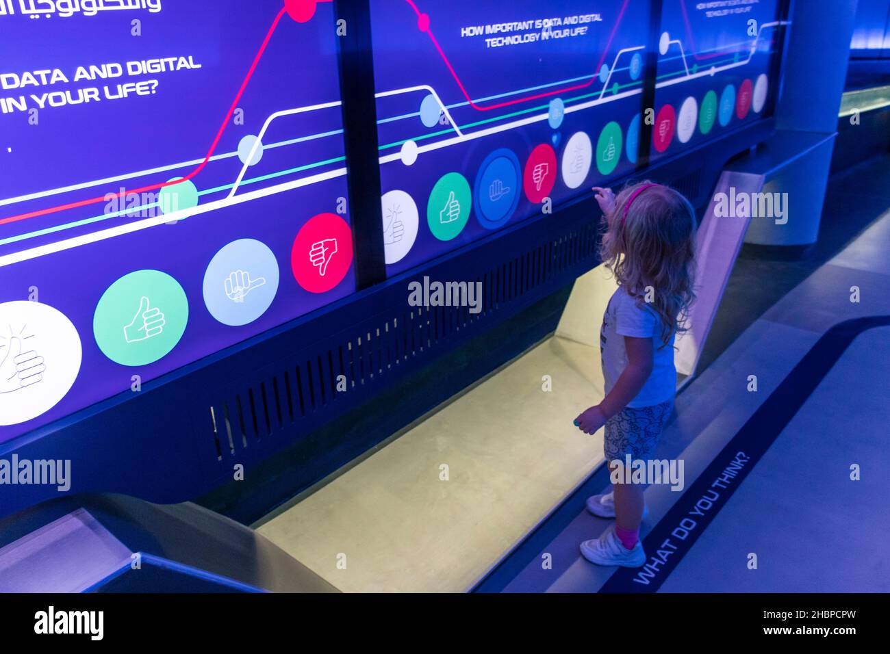 Little girl plays with buttons of the interactive wall Stock Photo - Alamy