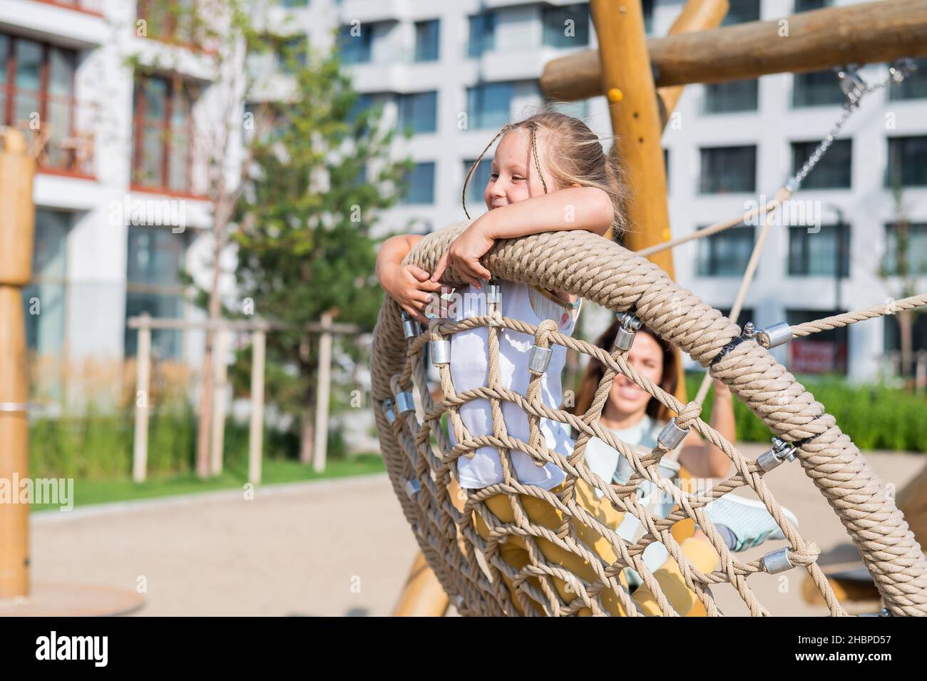 Mom and daughter swing on a round swing. Caucasian woman and little ...