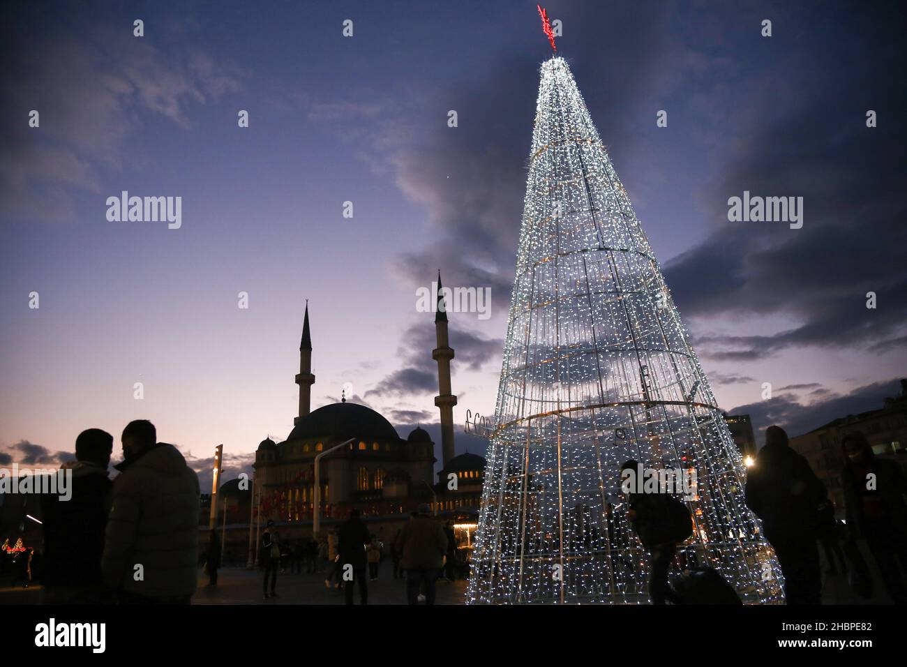 The Taksim Mosque is seen in the background of a lit Christmas tree in ...