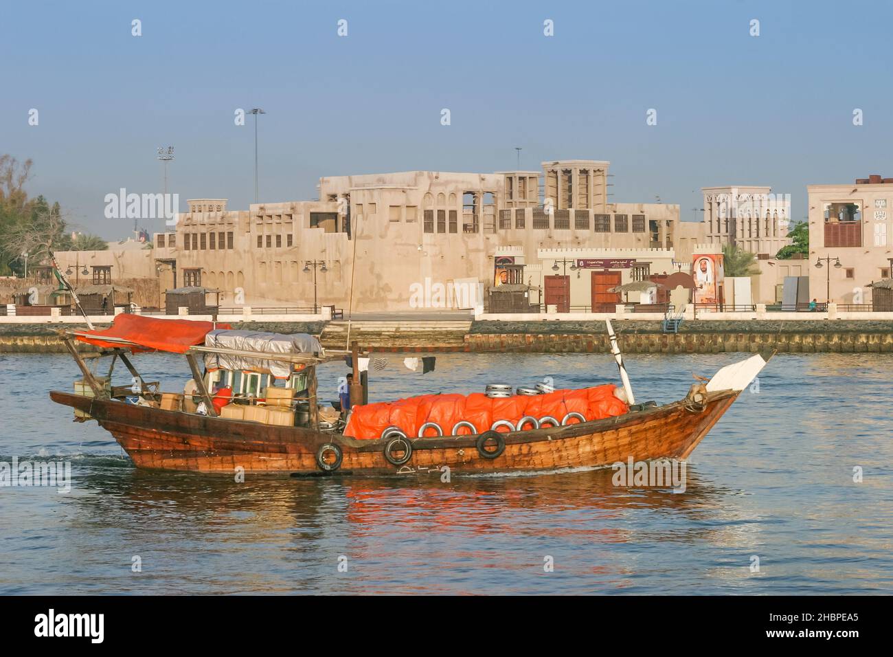 An historical view of a small dhow on Dubai Creek, with traditional ...