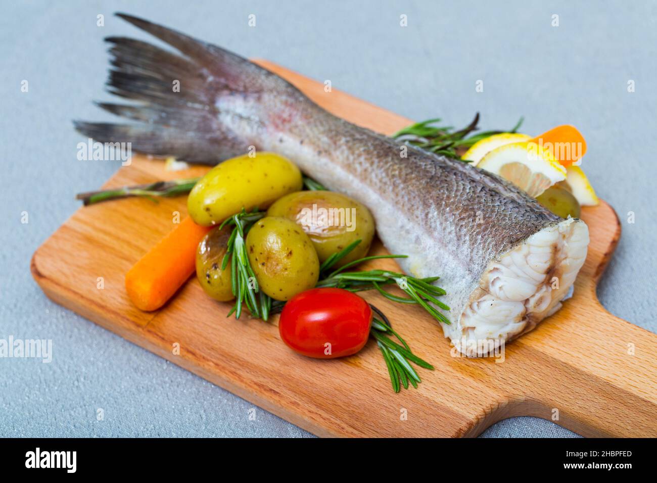 Country style baked merluccius Stock Photo - Alamy
