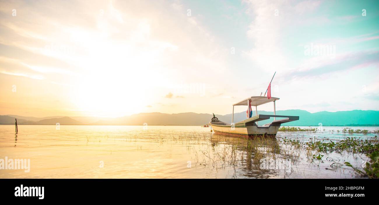 Beautiful sunset view of Timah Tasoh lake with a boat by the lakeside ...