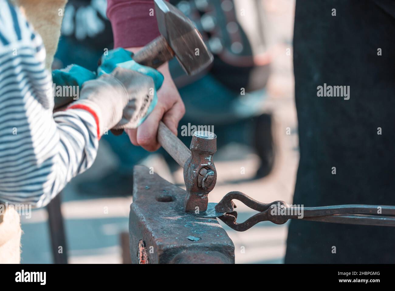 The blacksmith manually forging the molten metal on anvil Stock Photo ...