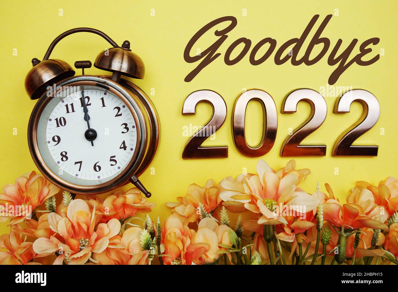 Goodbye 2022 text with alarmclock and flower decoration on yellow ...