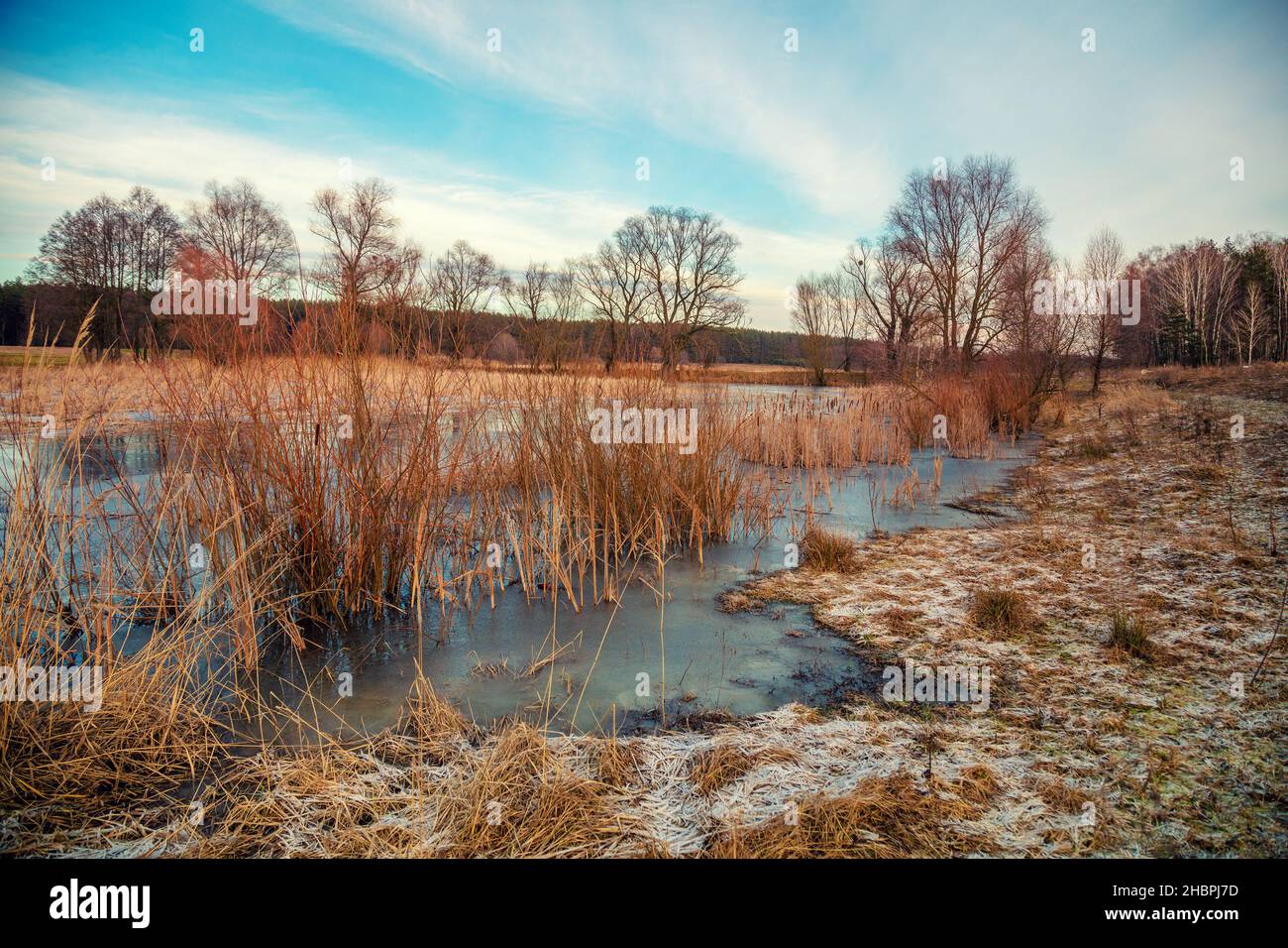 View of the countryside and frozen winding brook in the evening at ...