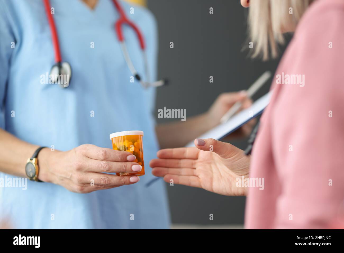 Female doctor in uniform give container with medication to patient ...