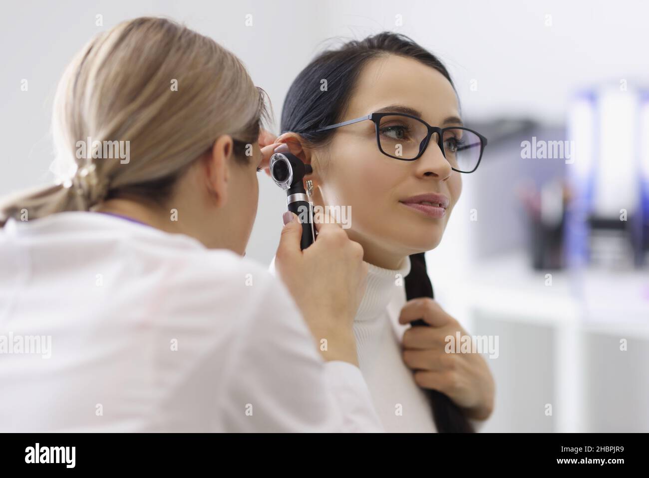 Doctor check patients ear on medical examination with special tool ...
