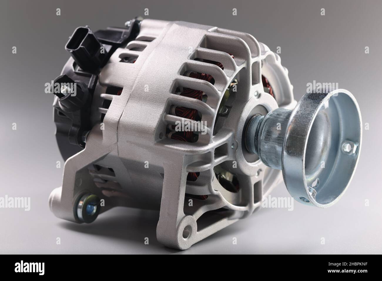 Metal motor with wire and plugs lies on grey surface, production of ...