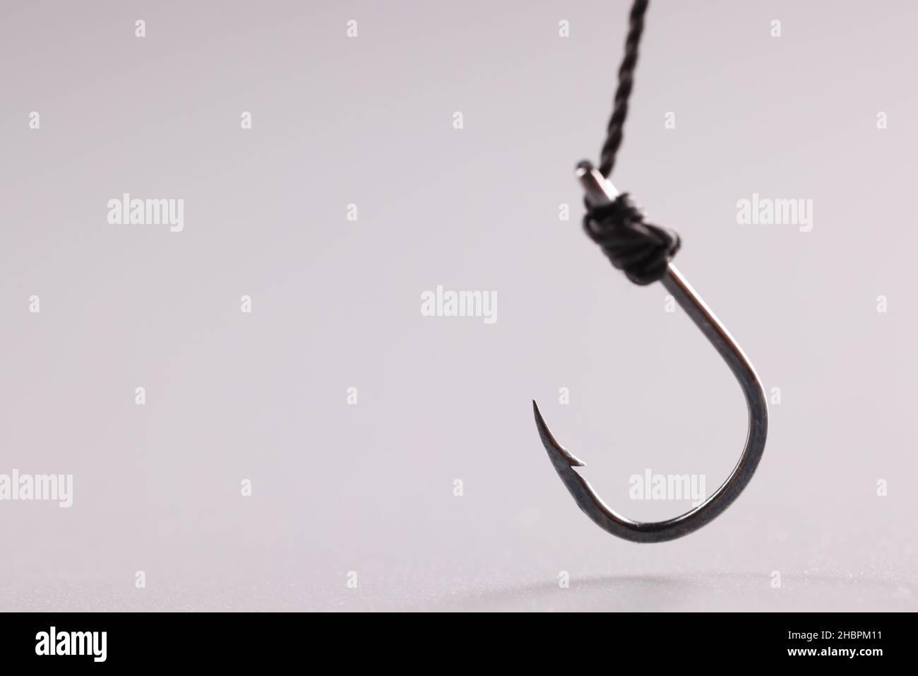 Hook attached to steel cable, single fish hook Stock Photo - Alamy