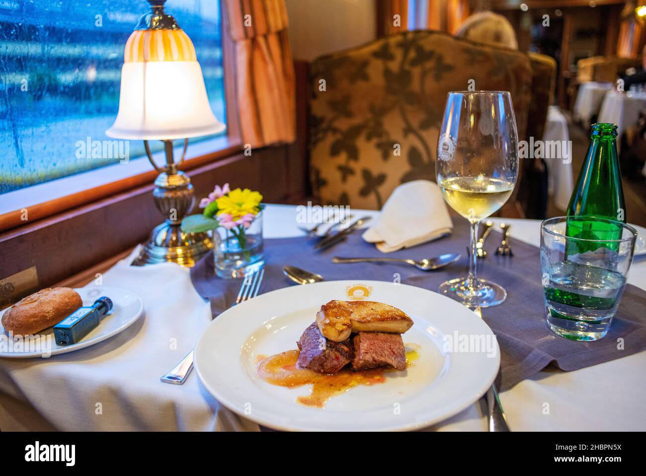 Beef tenderloin and foie dish. Interior of restaurant car railway ...