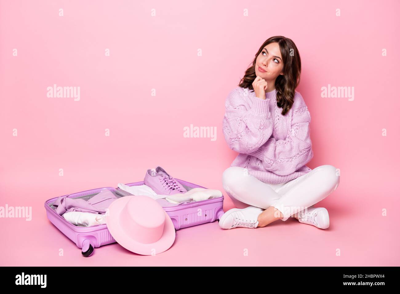 Portrait of nice minded girl packing things bag deciding thinking copy ...