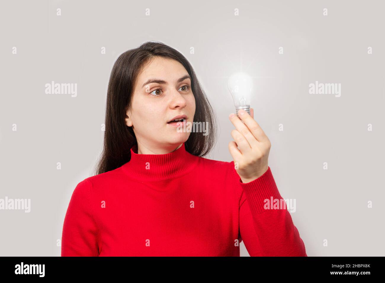 A surprised brunette woman with her mouth open in red looks at a ...