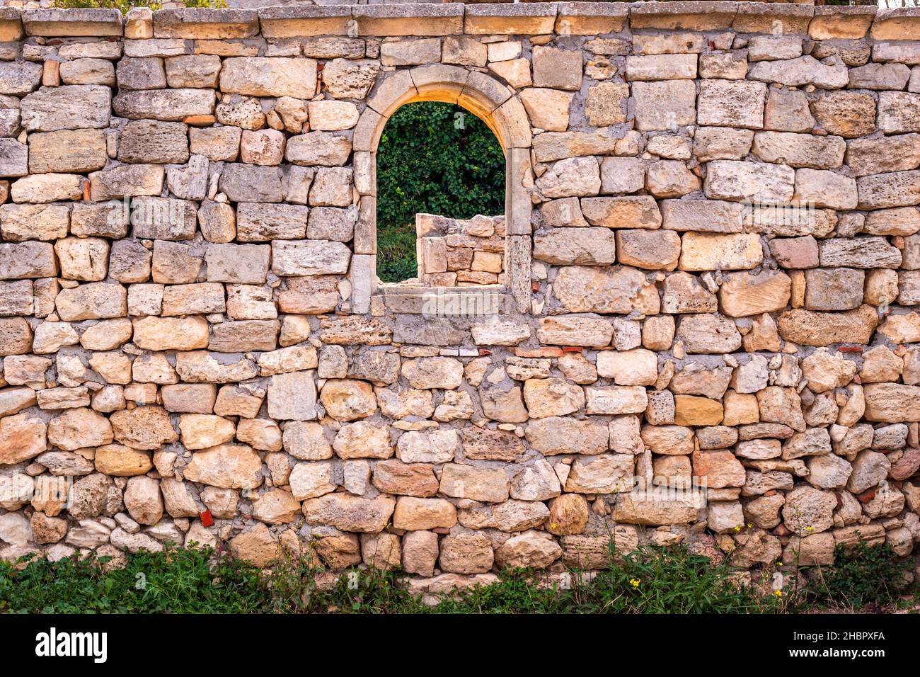 part of an old stone wall with an arched window opening in the ...