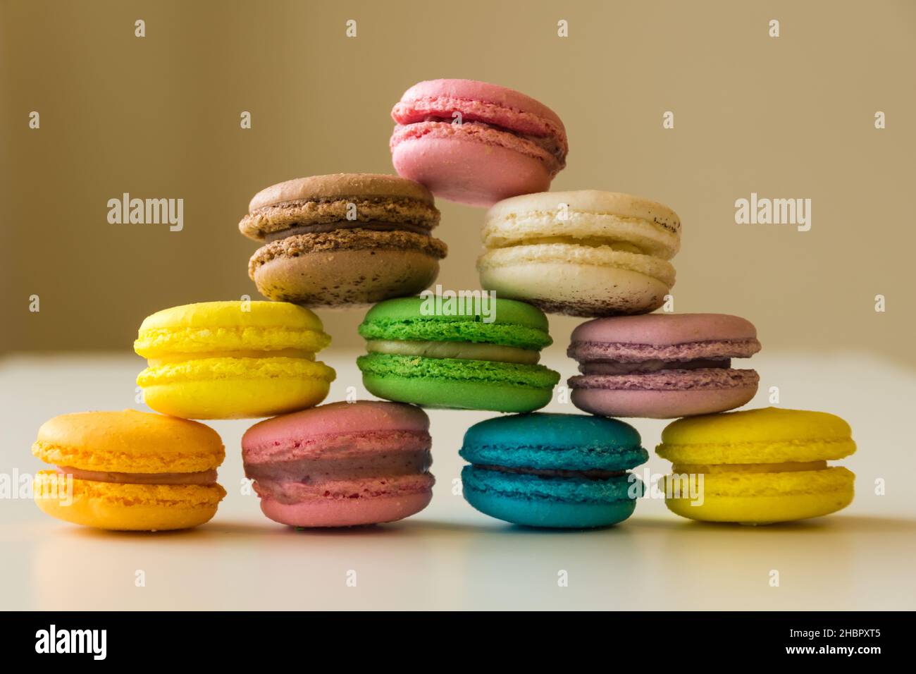The colorful macarons stacked in a pyramid form on a white table Stock ...
