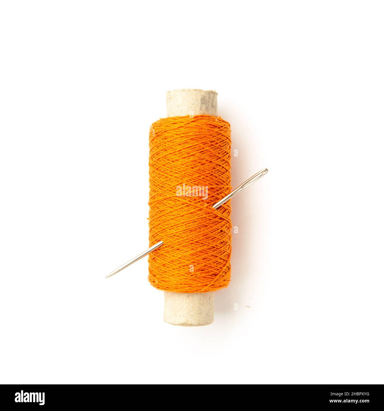 Spool of orange thread with needle isolated on white background Stock ...