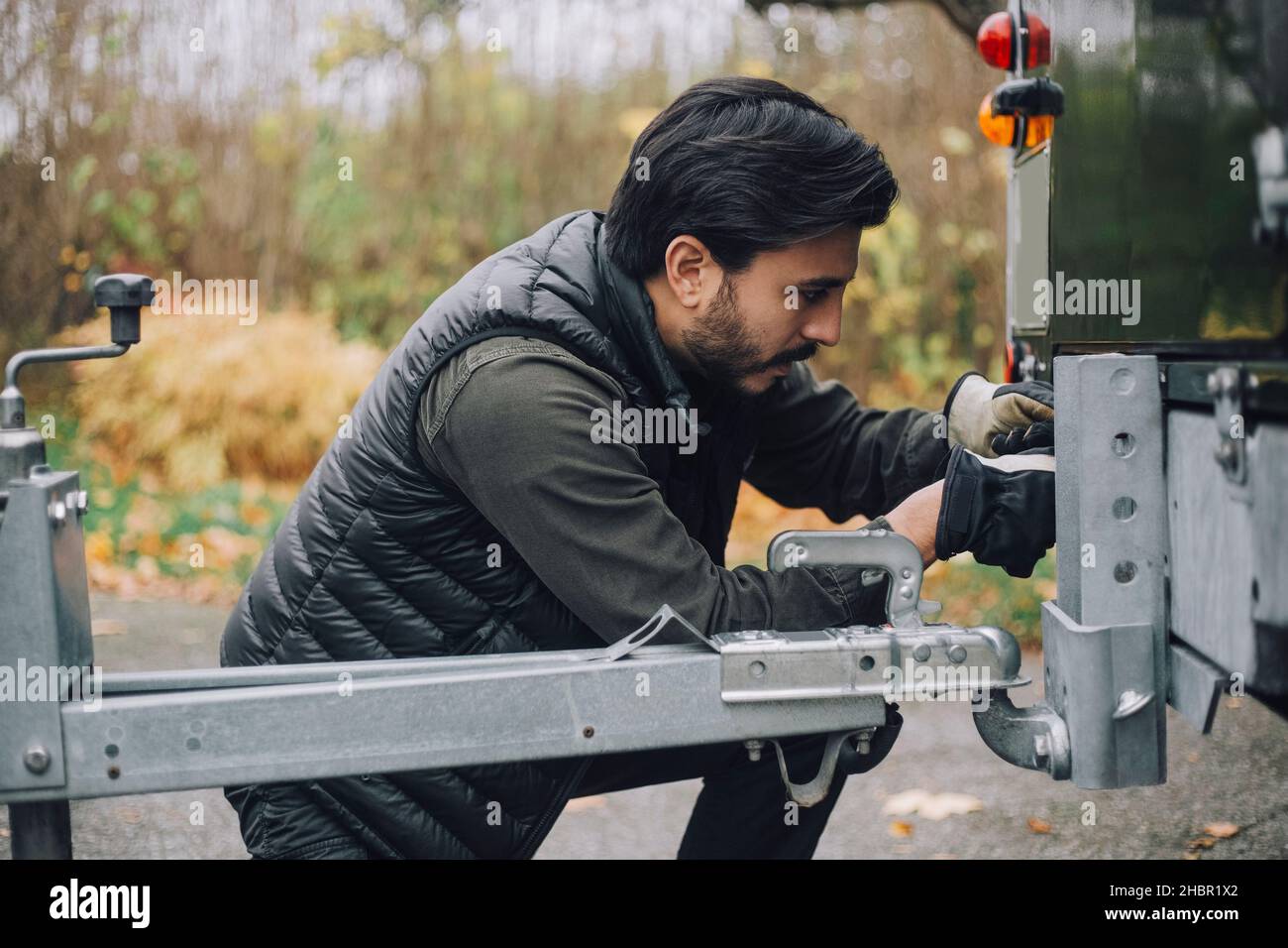 Man towing trailer to sports utility vehicle on driveway Stock Photo ...