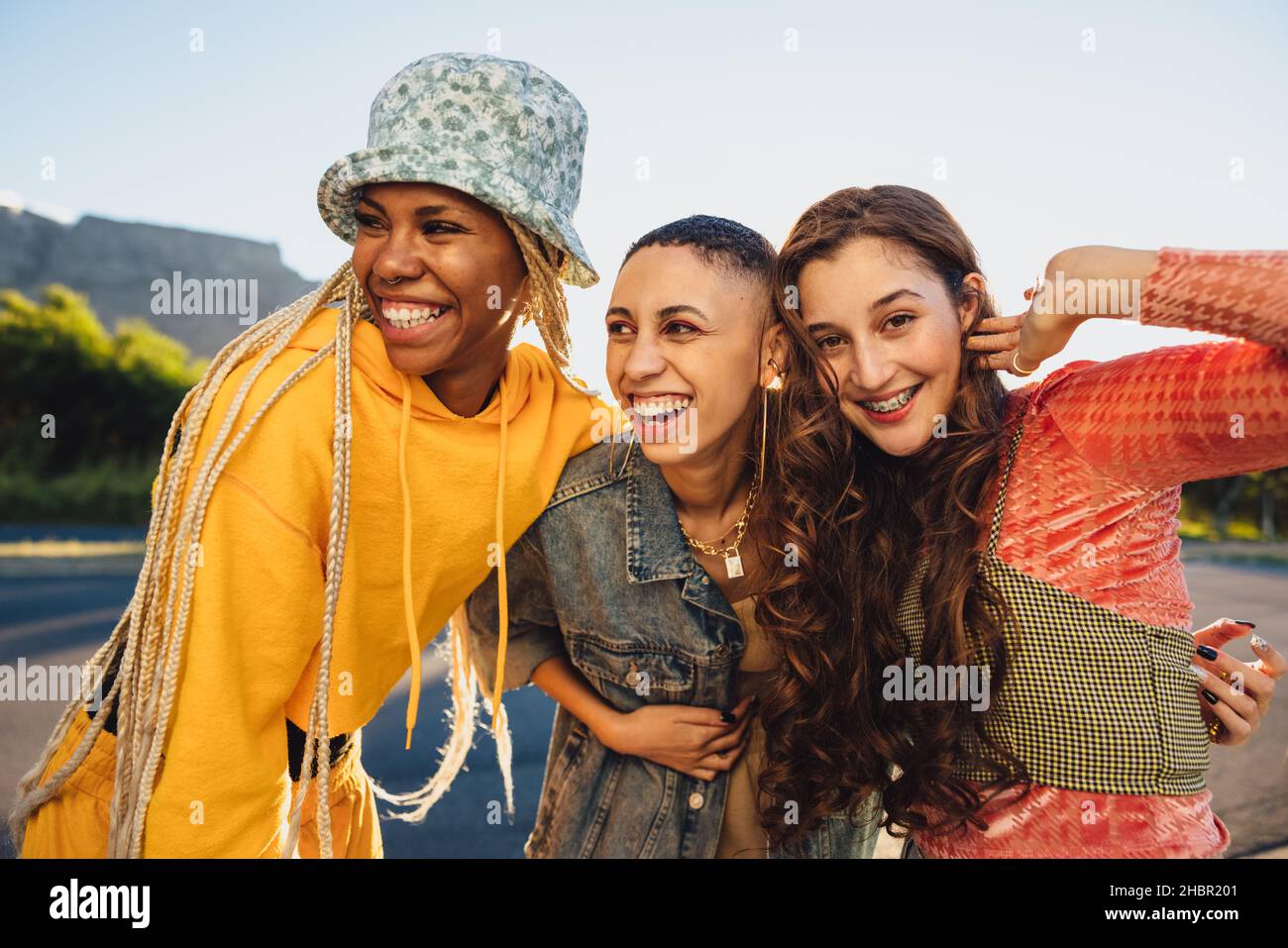 Three female friends smiling while embracing each other. Female ...