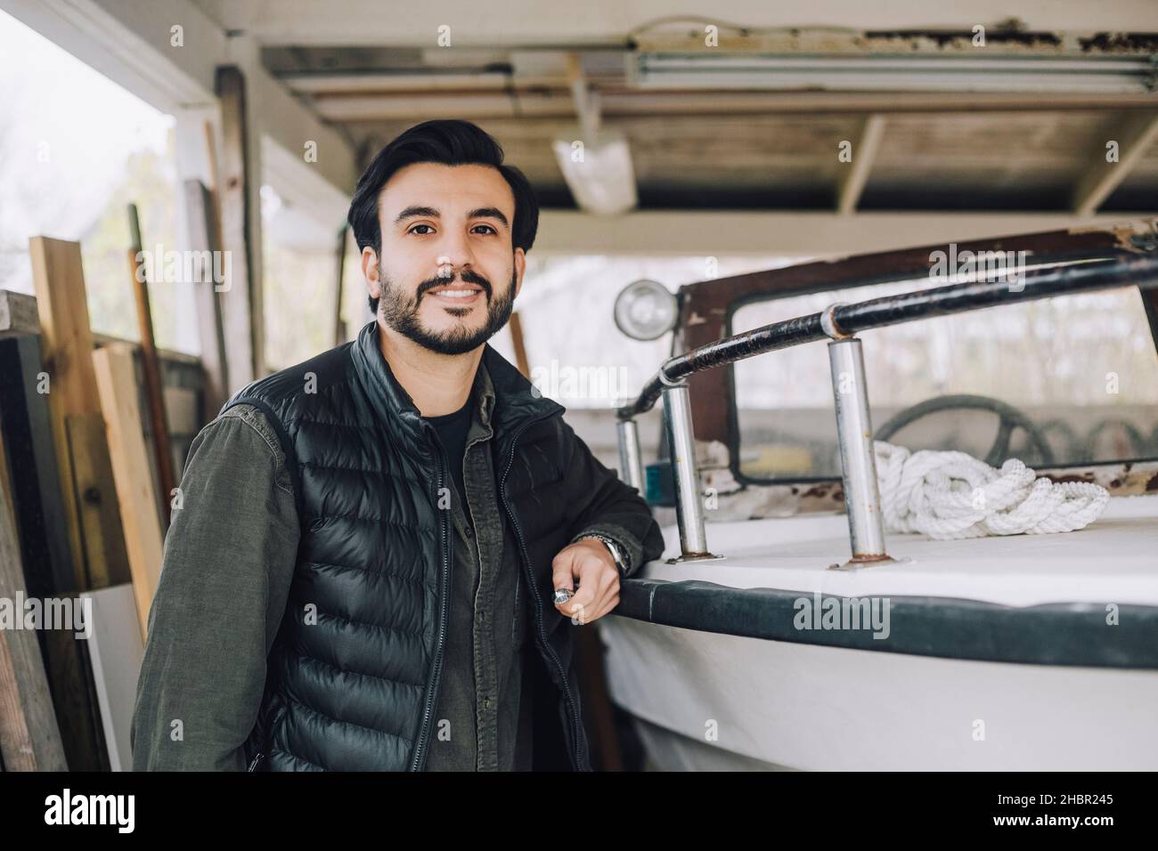 Portrait of man by nautical vessel in garage Stock Photo - Alamy