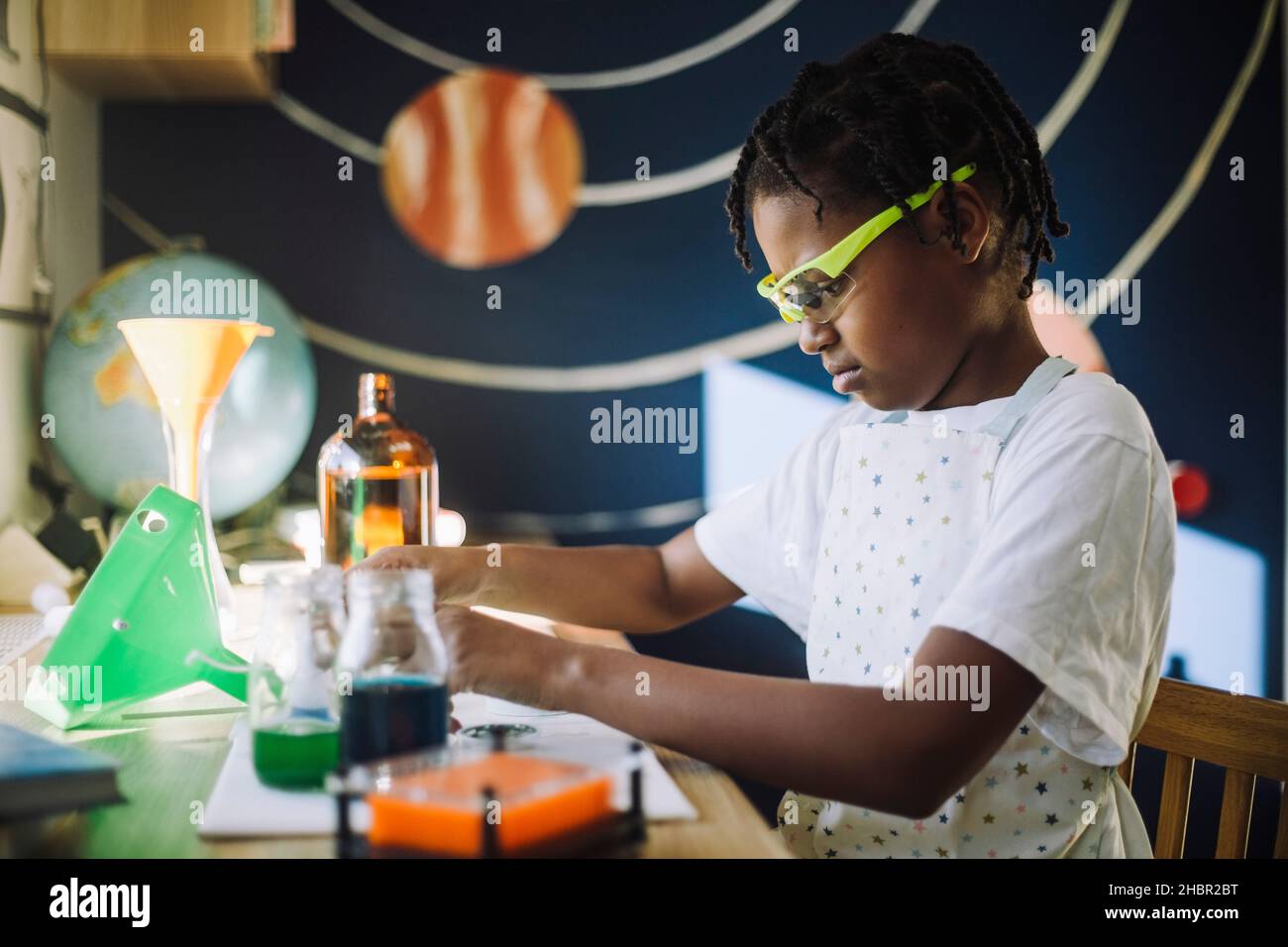 Female student concentrating while doing science project at table Stock ...