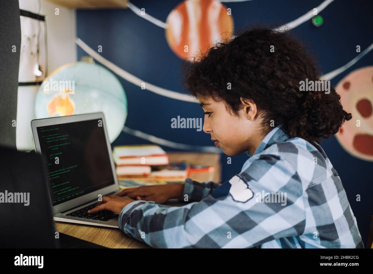 Girl concentrating while learning coding on laptop at home Stock Photo ...