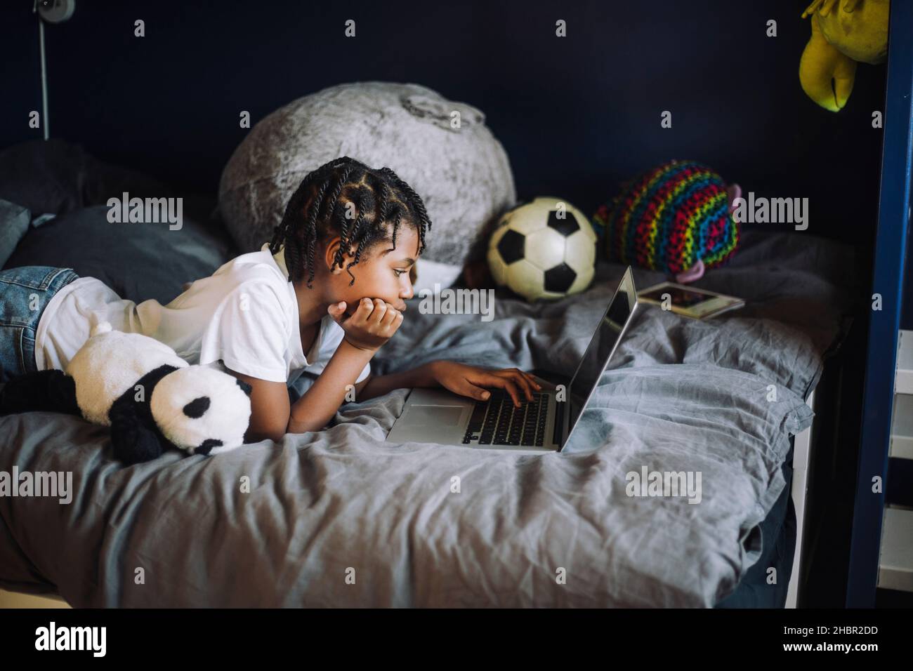 Ambitious girl learning coding on laptop in bedroom Stock Photo - Alamy