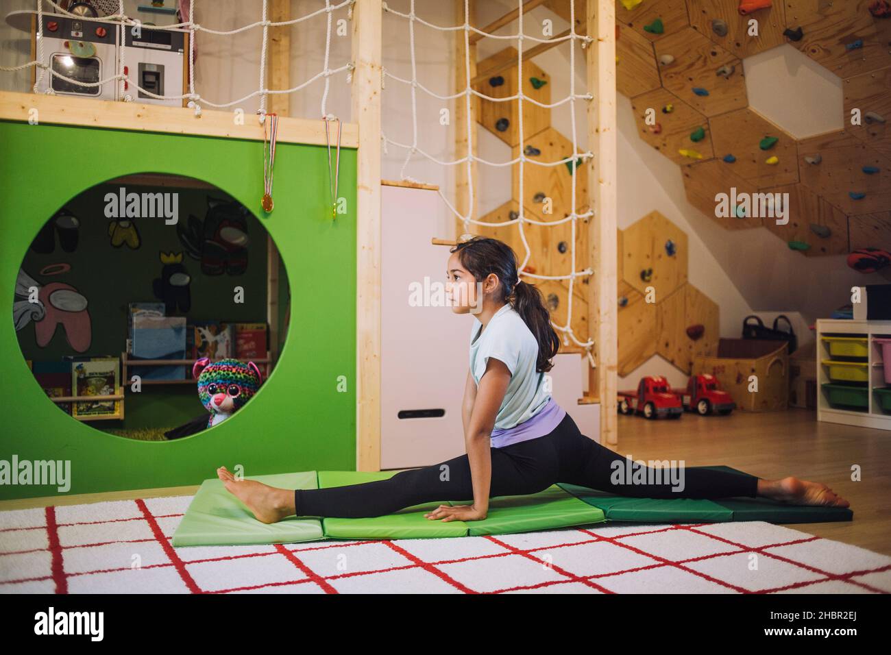 Active girl doing splits while exercising at home Stock Photo - Alamy