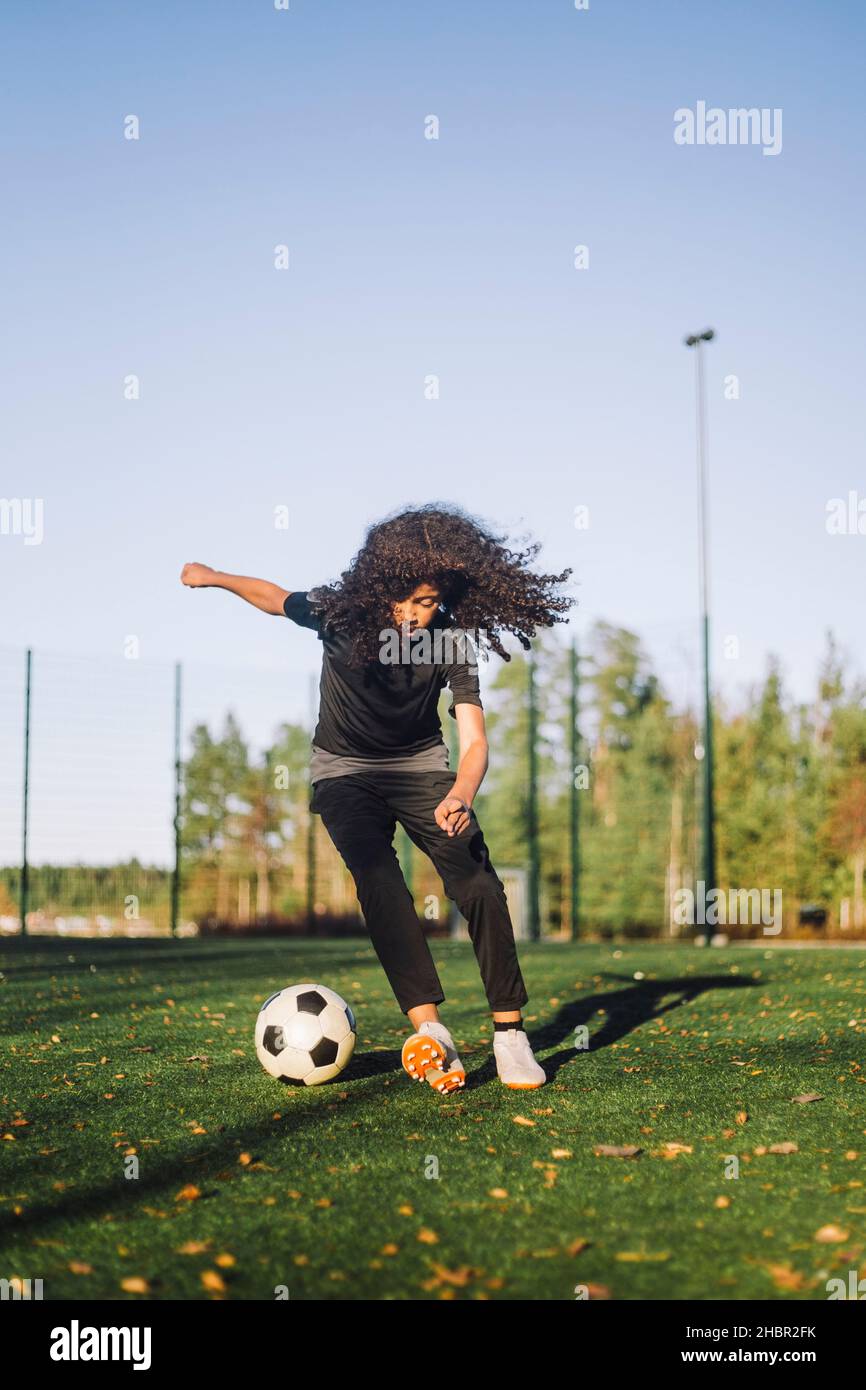 Girl playing soccer on sports field during sunny day Stock Photo - Alamy