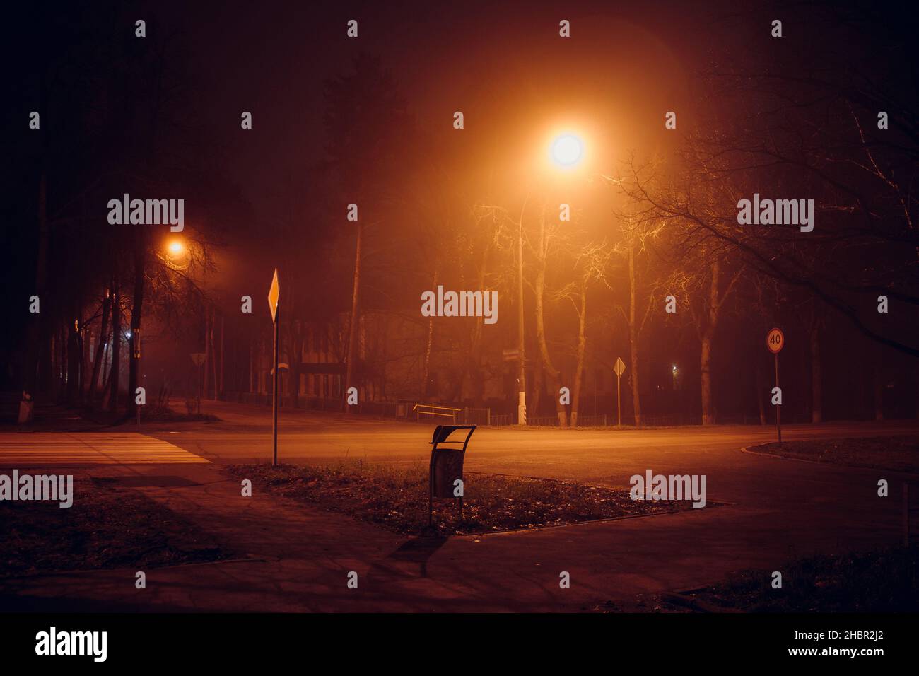 Empty intersection at night during low fog Stock Photo - Alamy
