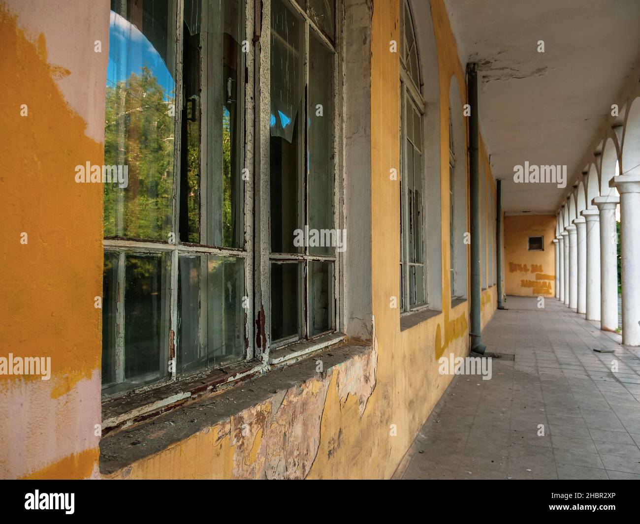 Long passage along the old abandoned building with high french windows ...