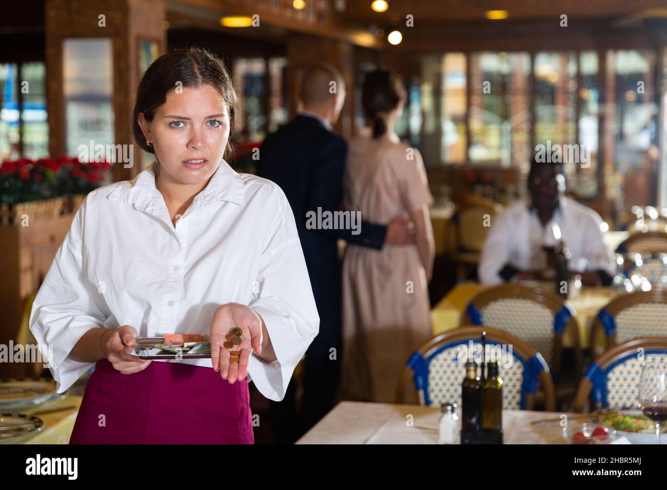 Portrait of upset waitress disappointed in small tip from guests at ...
