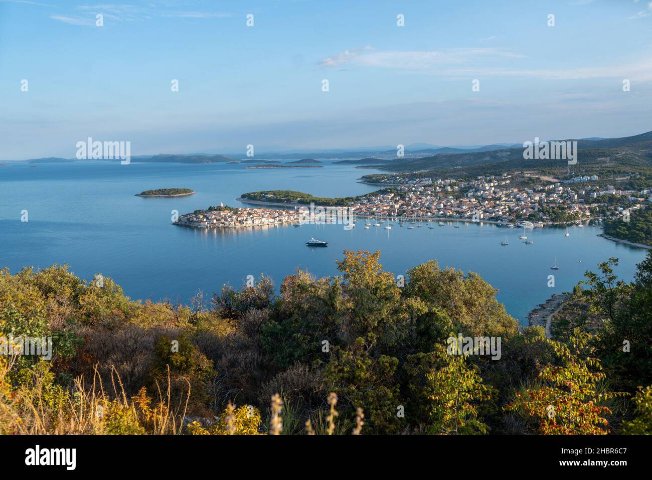 A scenic view of a calm sea and a cityscape with buildings on a ...