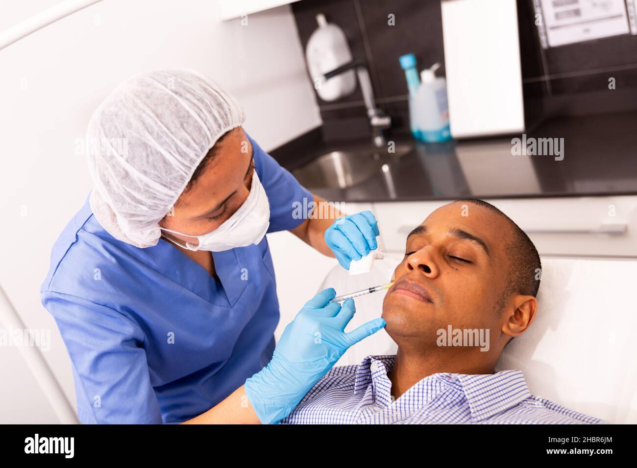 Experienced female beautician working with Hispanic male client in ...