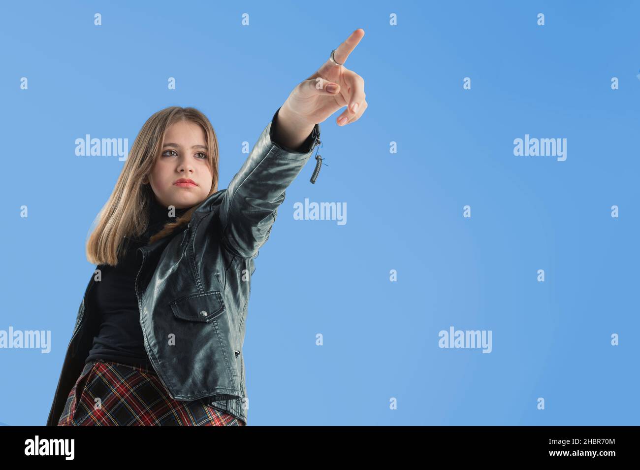 Portrait of a pretty girl pointing finger away. Girl showing the ...