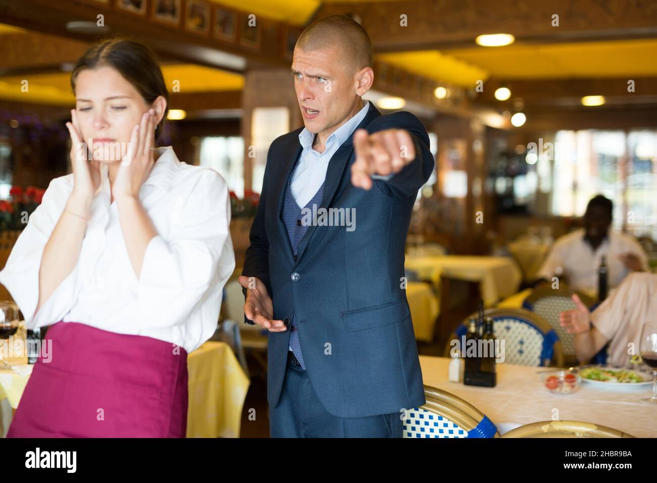 Owner of restaurant shouts at the guilty waiter Stock Photo - Alamy