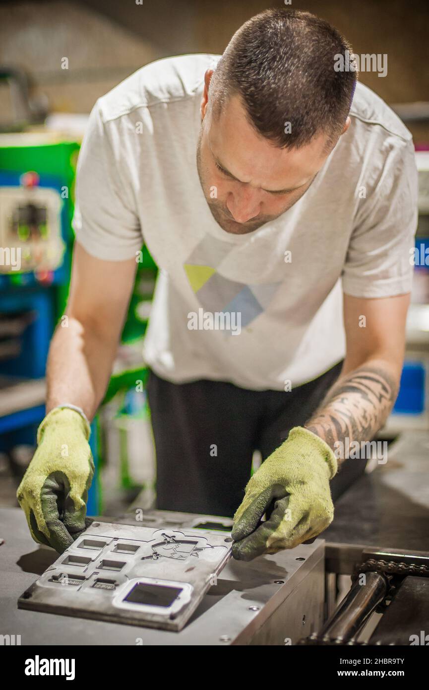 Refrigerator Magnets. Professional worker technician making magnet for ...