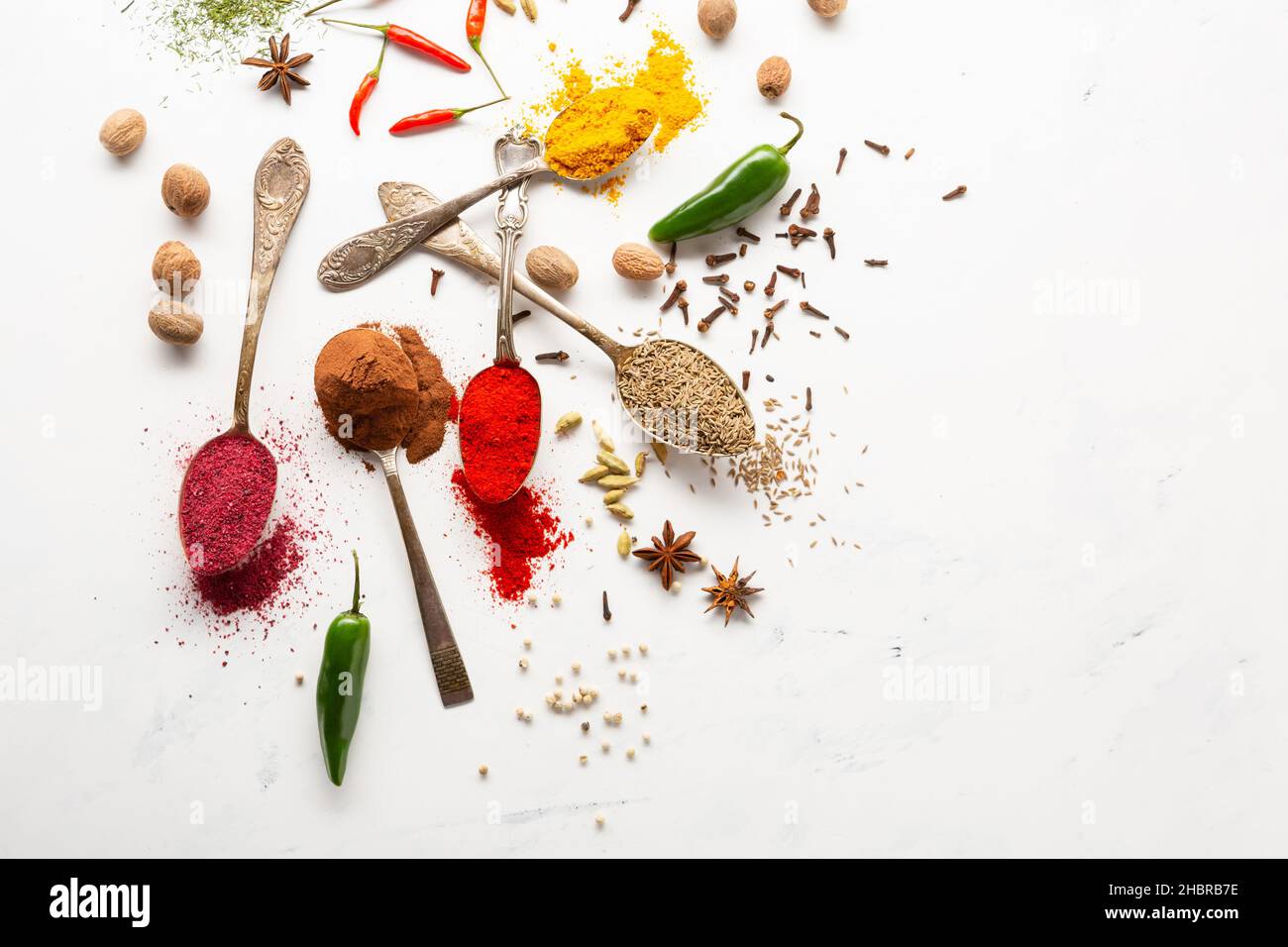Spice and condiment on spoons and white surface top view cooking ...