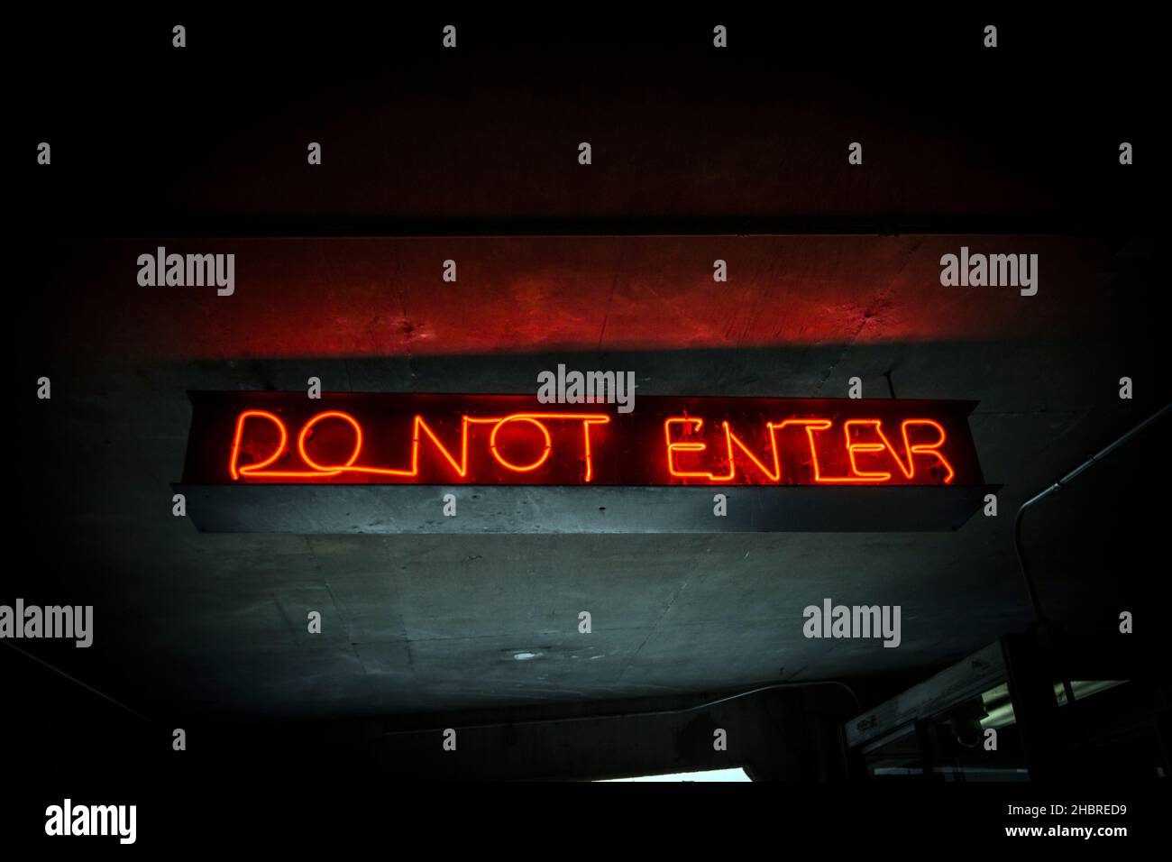illuminated red neon do not enter sign in the entrance to a multi ...