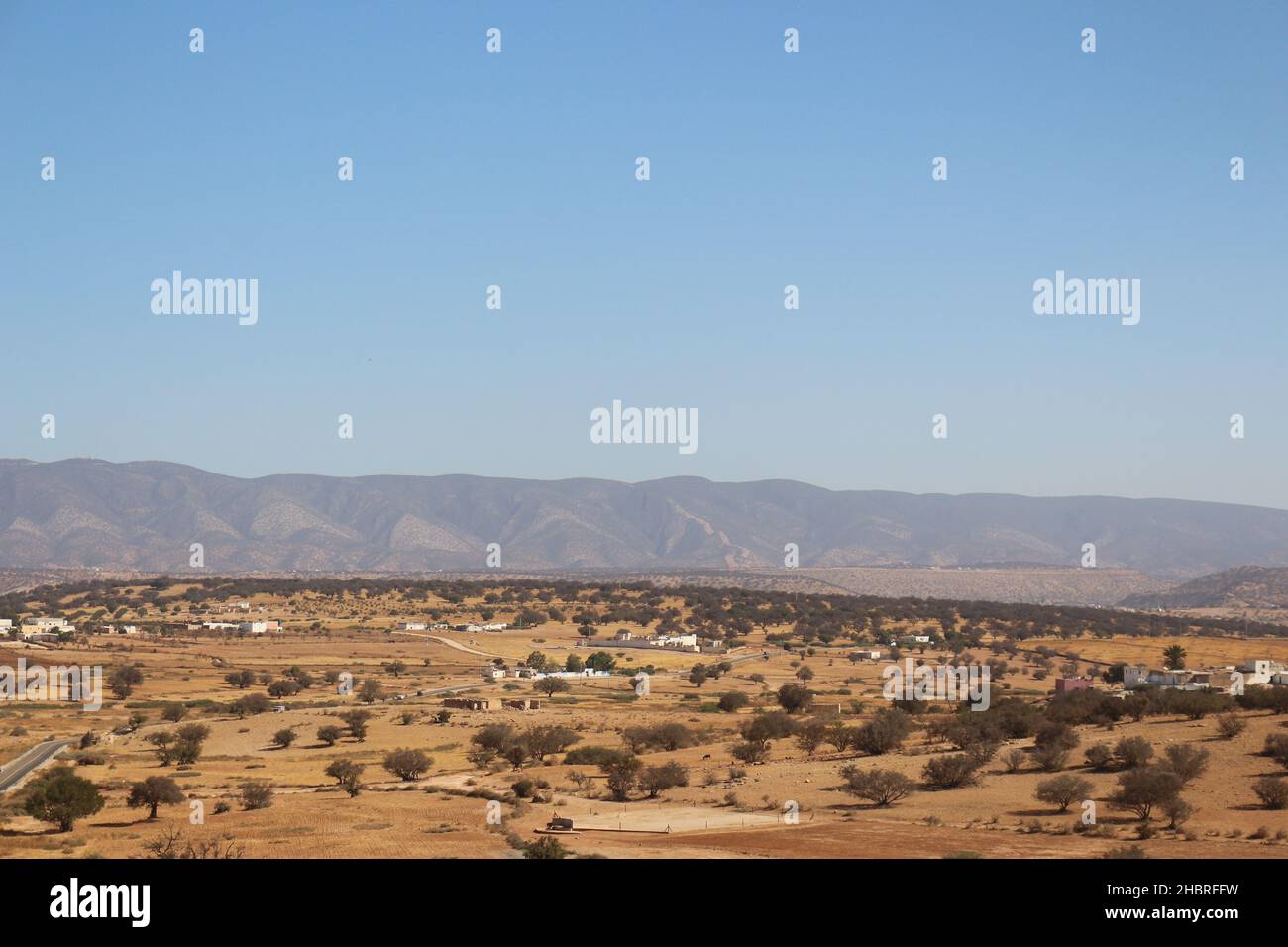 A landscape of a deserted area with poor vegetation under the blue ...