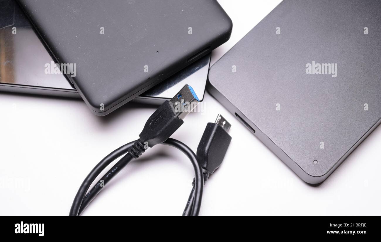 Portable external hard disc drives with USB 3.0 cable on white ...
