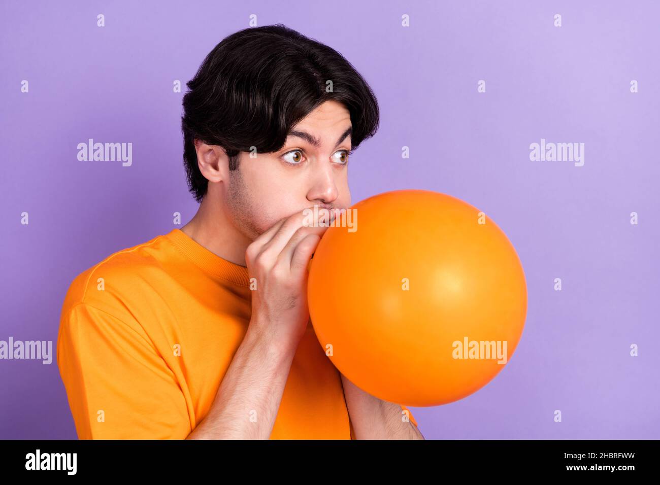 Photo of young happy funky positive man hold hands balloon inflate blow ...