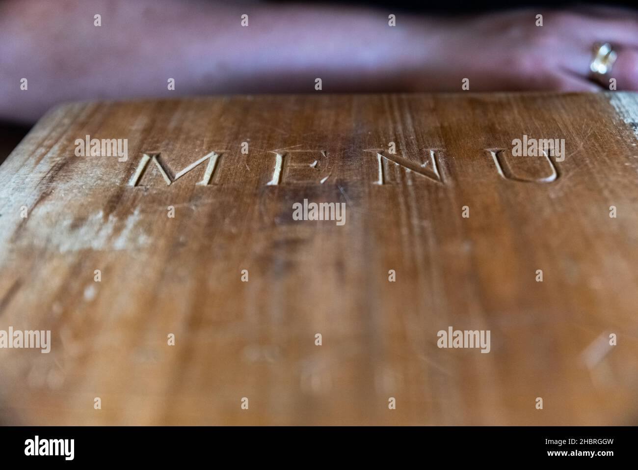 Wooden cover of the menu card with the inscription. Scratched and ...