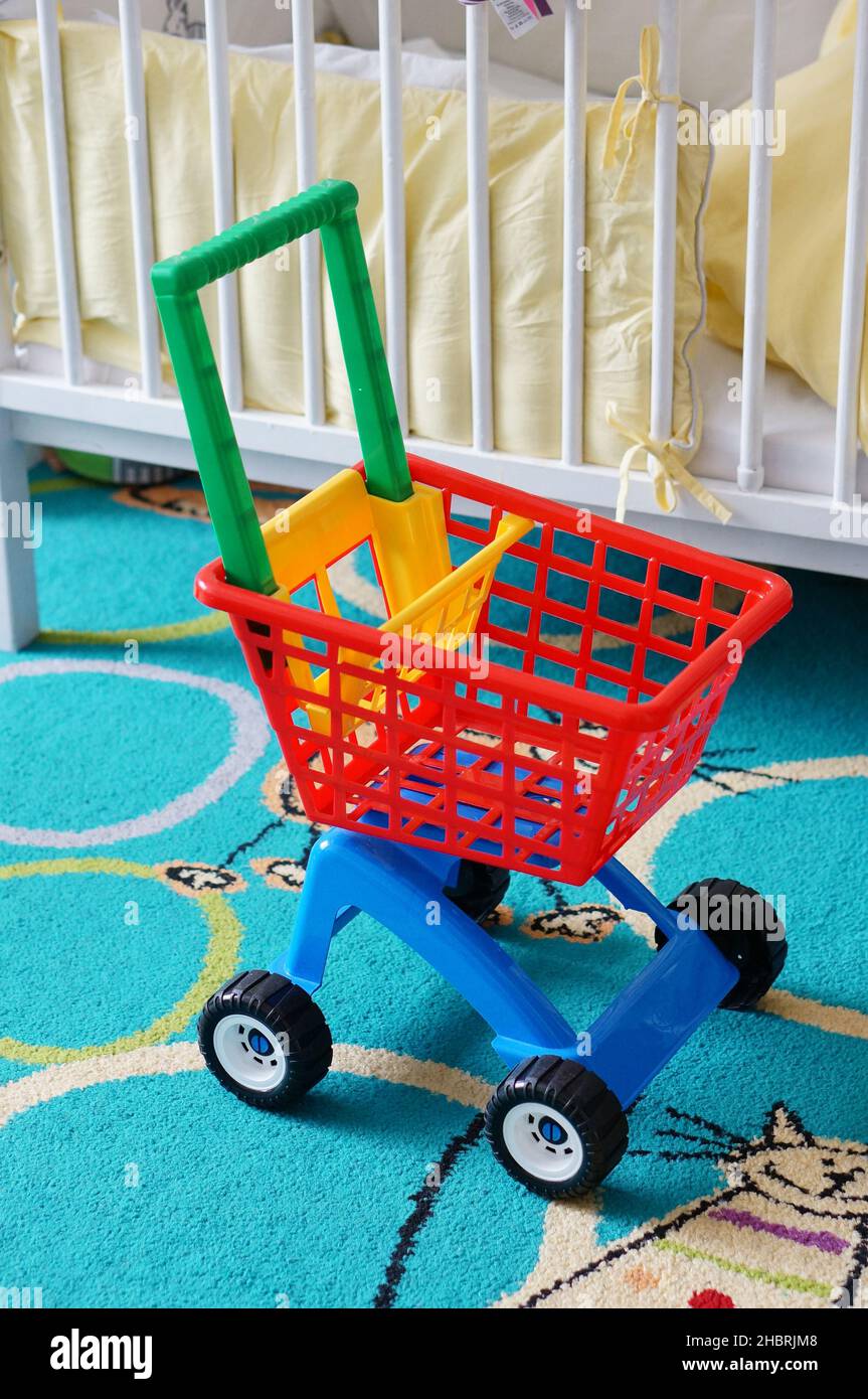 A Mini plastic Simulation Shopping Cart for Kids on a blue kid carpet ...