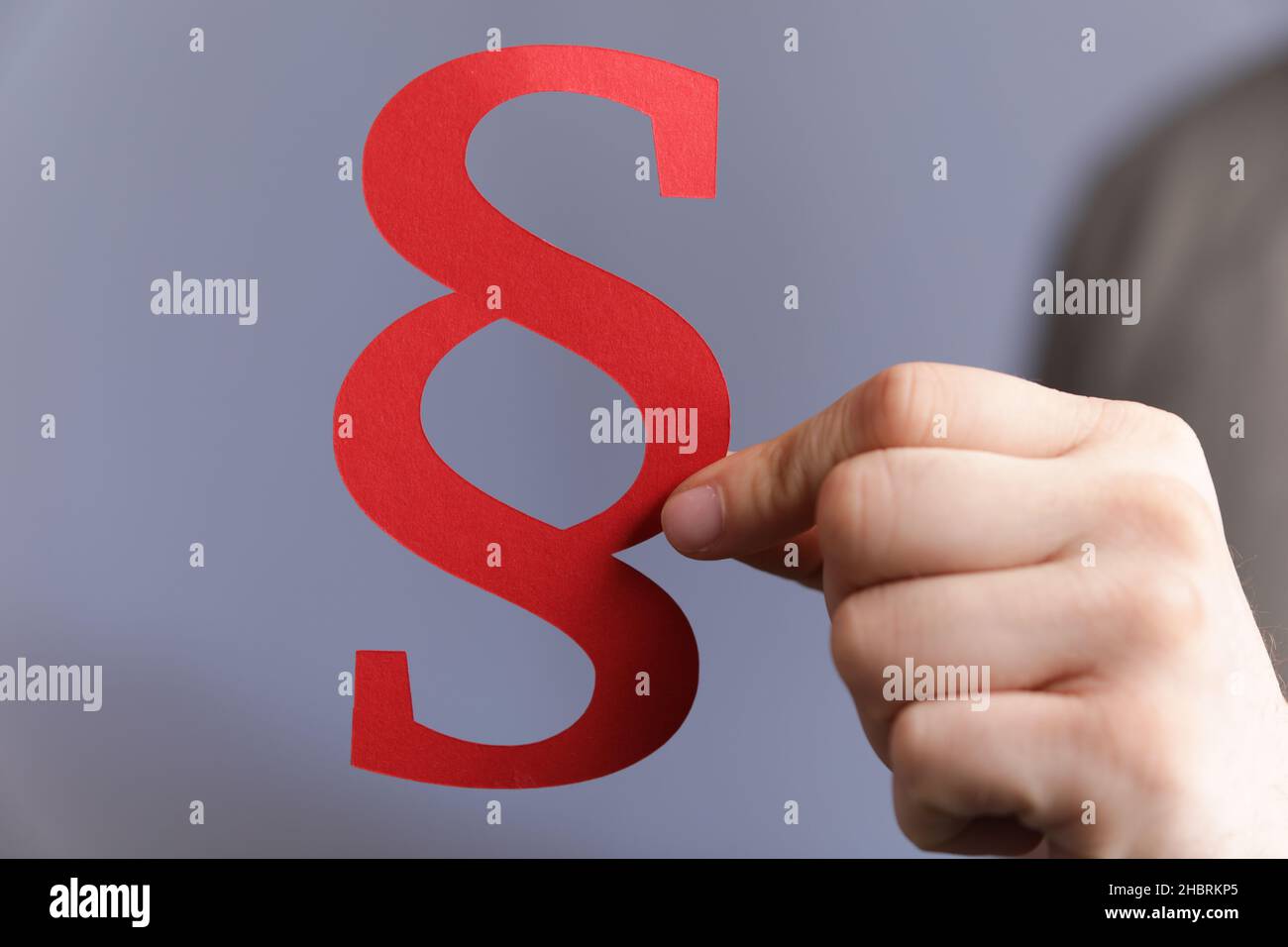 A male hand holding a red paragraph law sign Stock Photo - Alamy