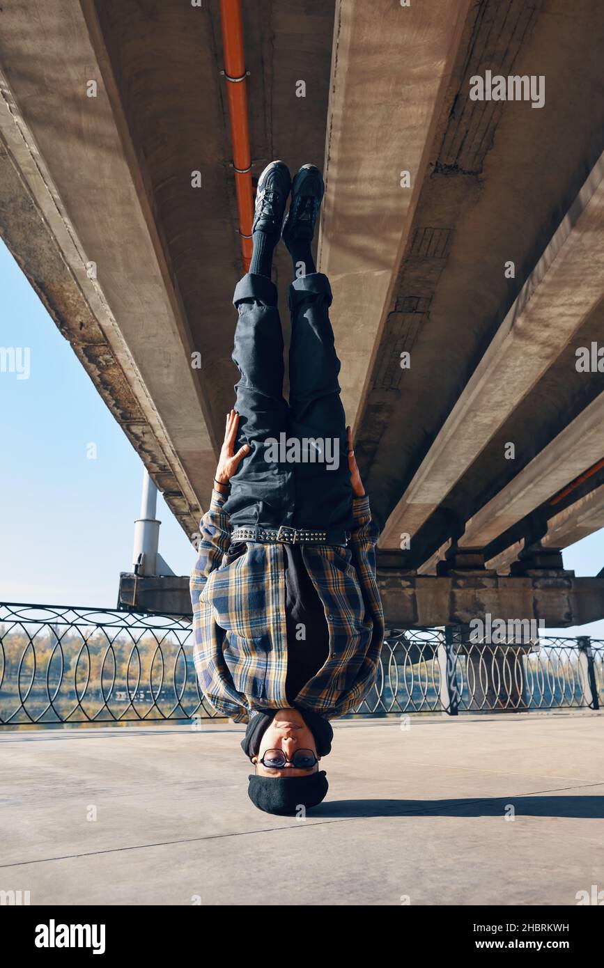 Young man break dancer dancing on urban background performing head ...