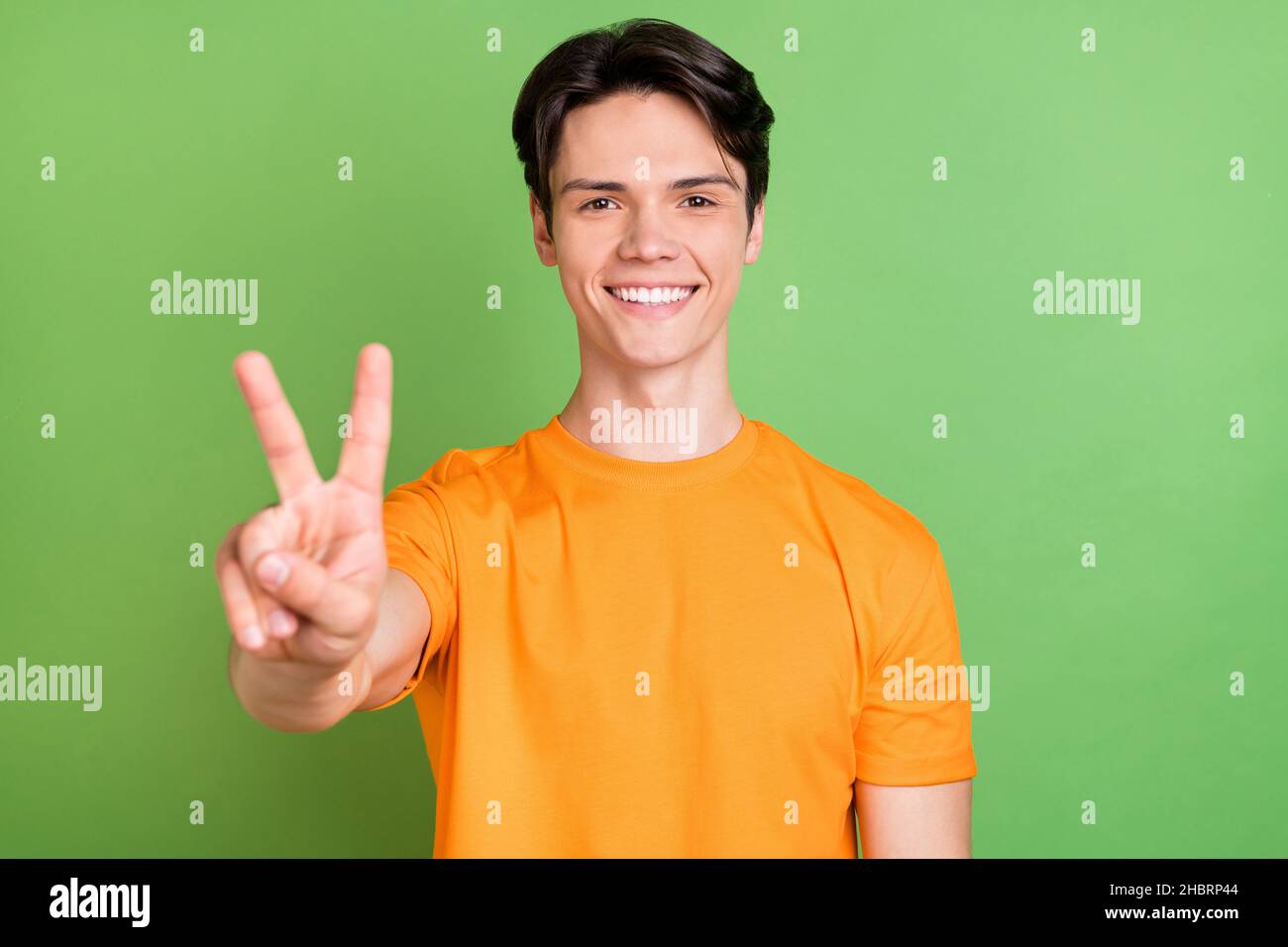 Photo of charming happy young man show two fingers count v-sign hello ...