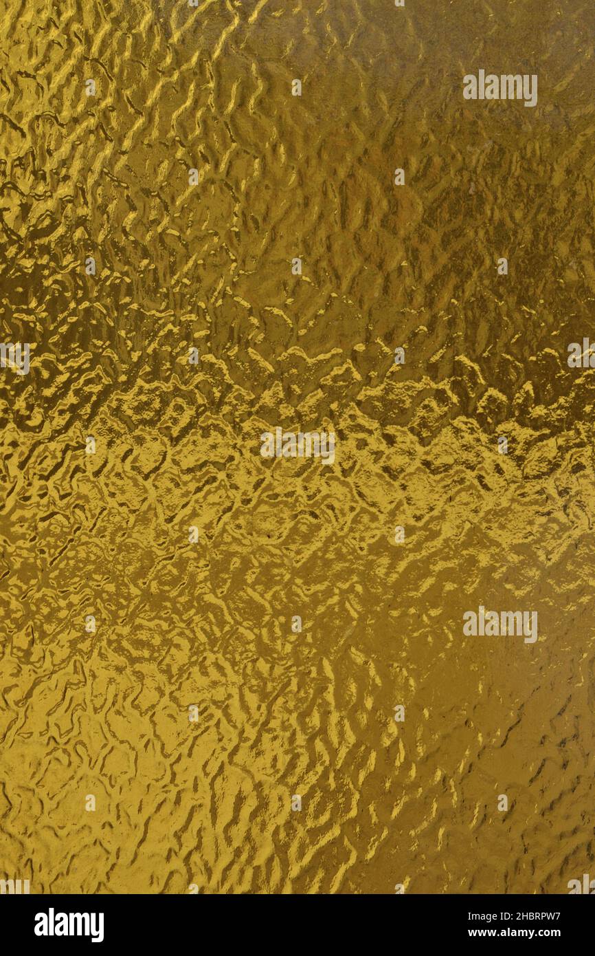 A vertical closeup of a gold-colored glass as a wonderful background ...
