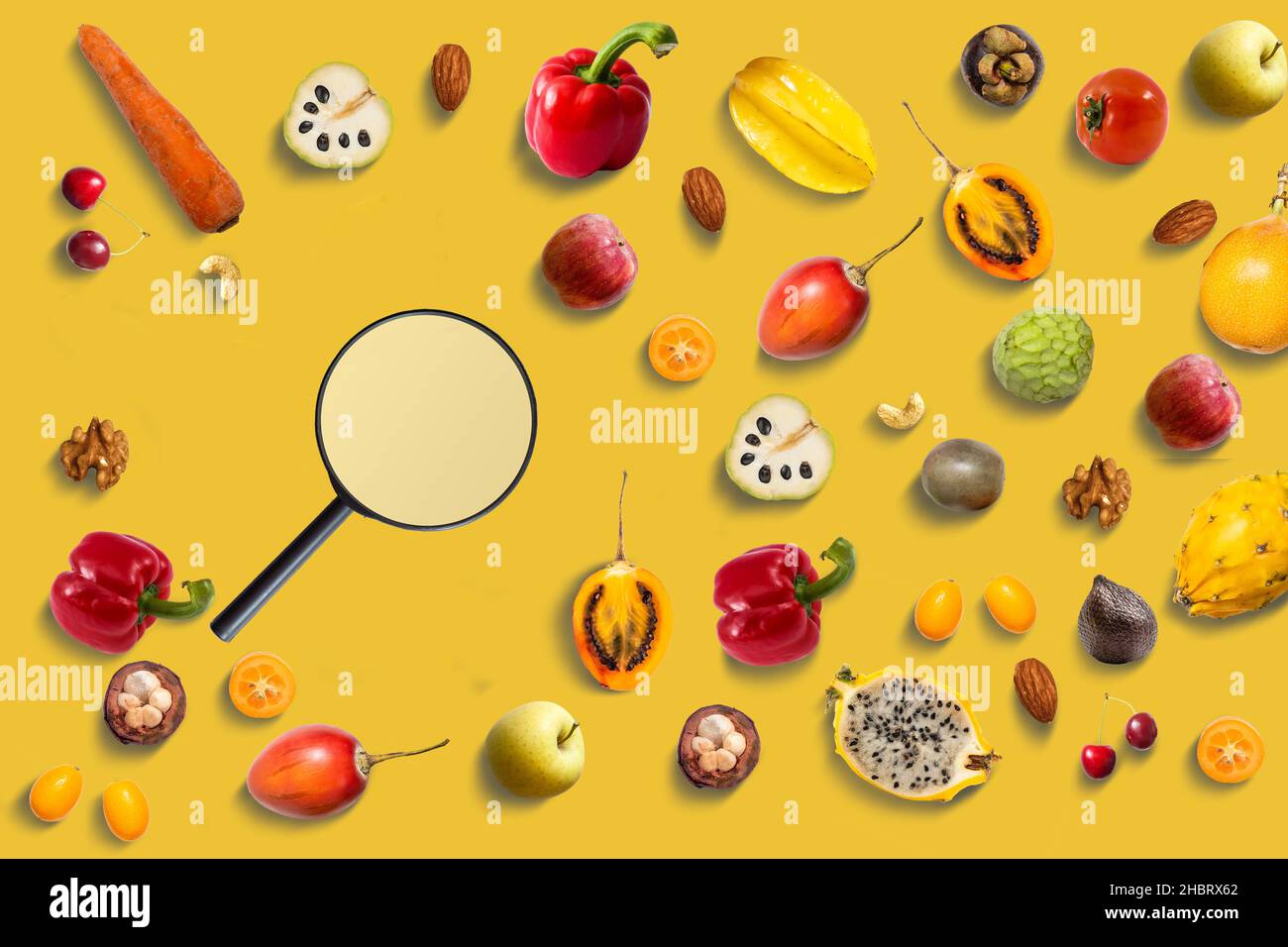 Fresh fruits, vegetables and magnifying glass on white table against ...