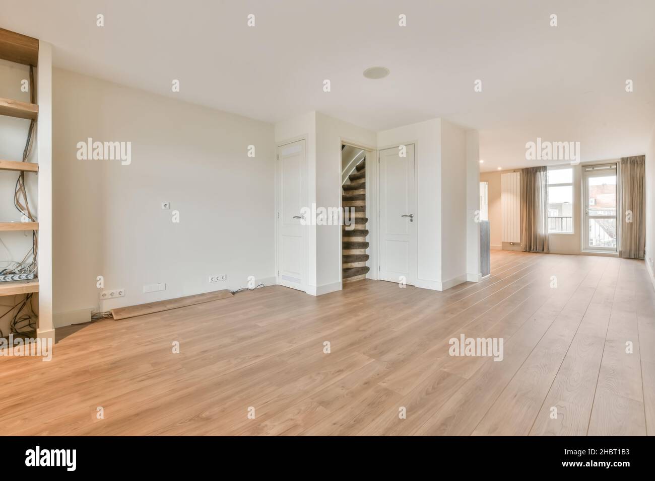 Large room with dark parquet floor and adjoining staircase Stock Photo ...